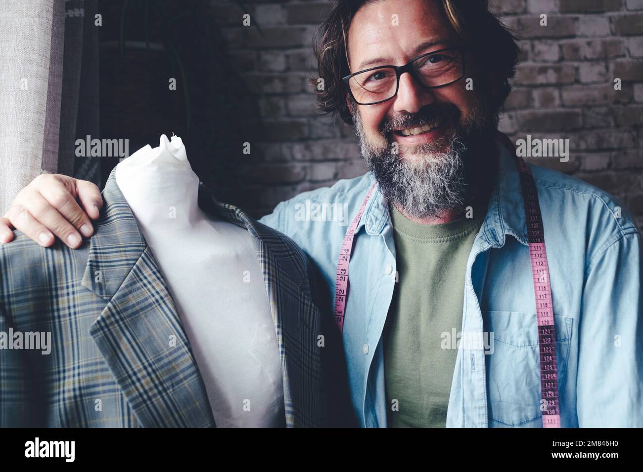 Professional portrait of tailor man smiling inside his workshop store ...