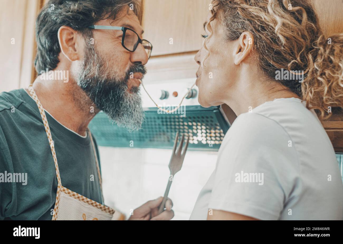 One man and woman eating spaghetti together in romantic activity. Happy ...