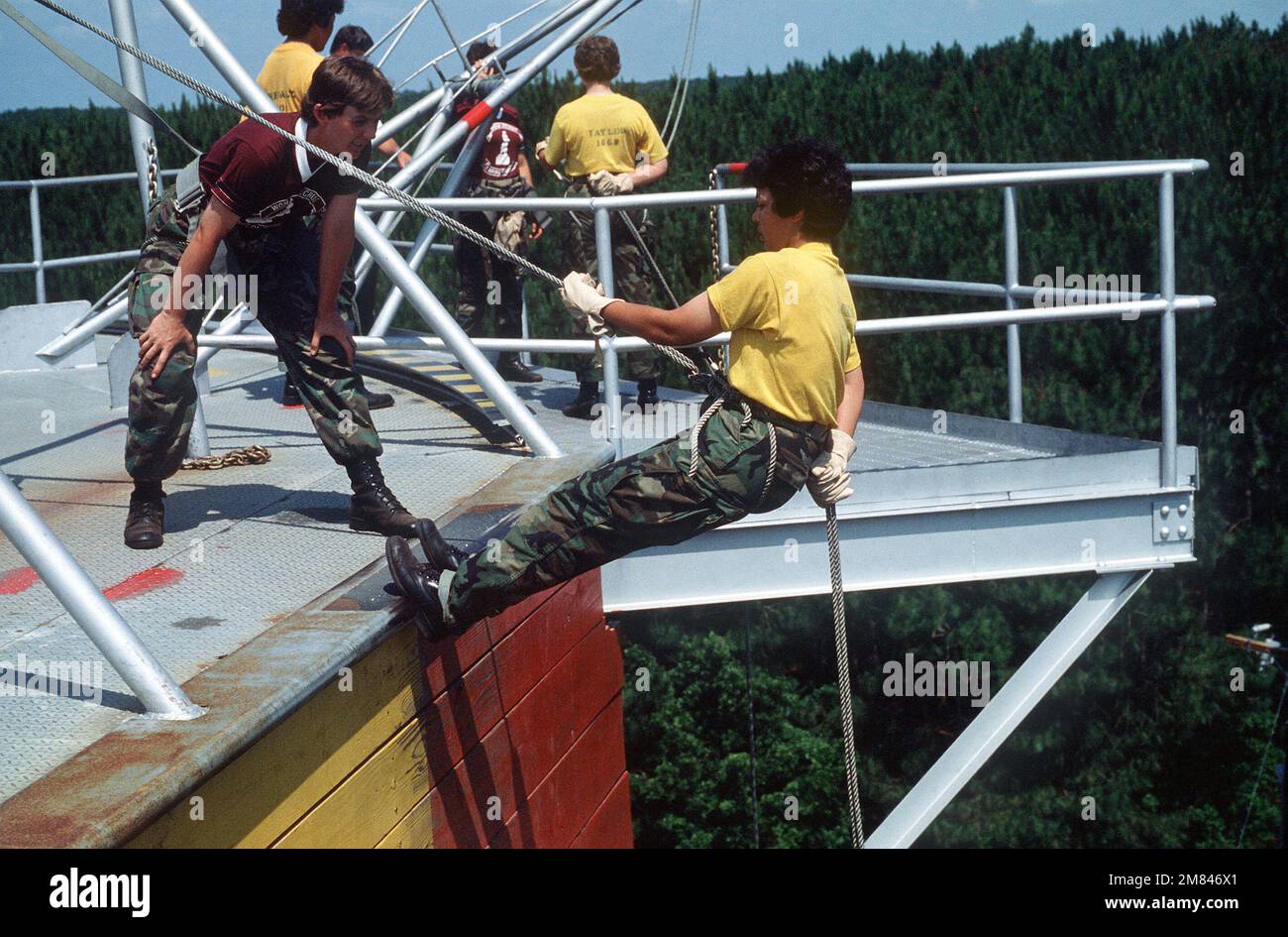 A drill instructor gives directions to a woman Marine recruit as she ...