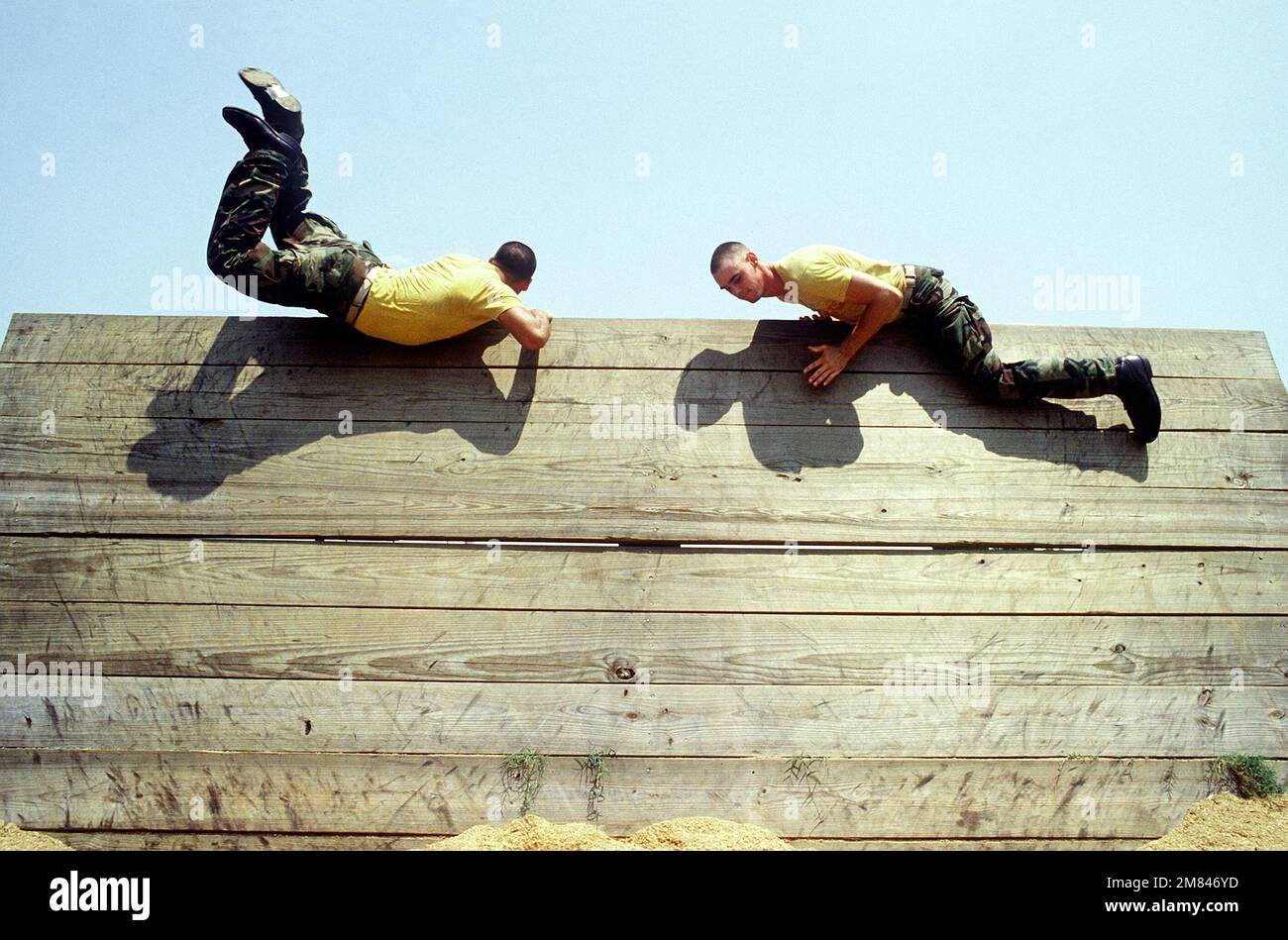 Marine recruits climb a wall on the obstacle course during basic ...