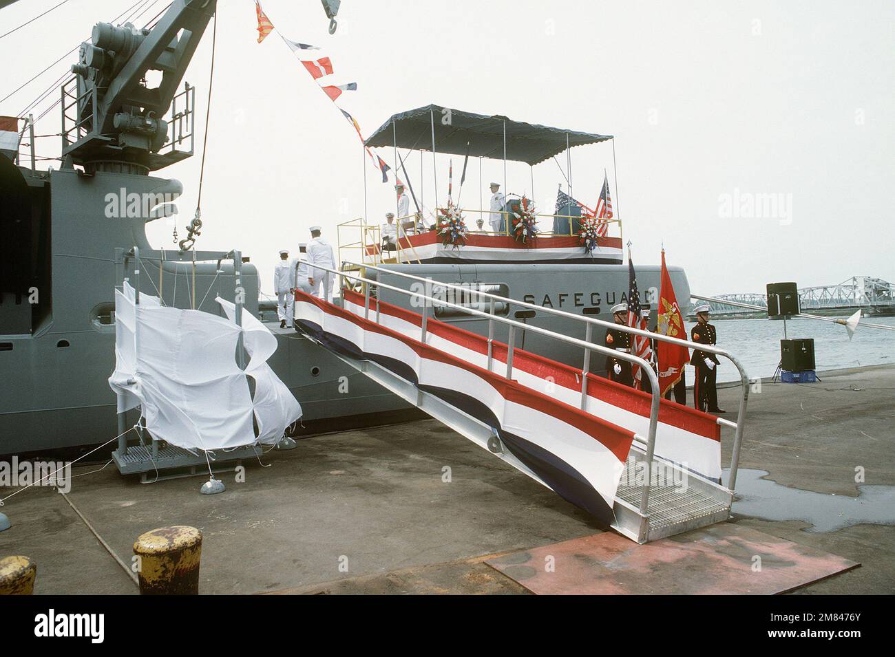 Crewmen go past the speakers platform as they board the USS SAFEGUARD ...