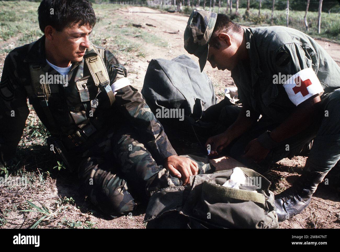 A U.S. Army medic administers first aid to the ankle of a Honduran ...