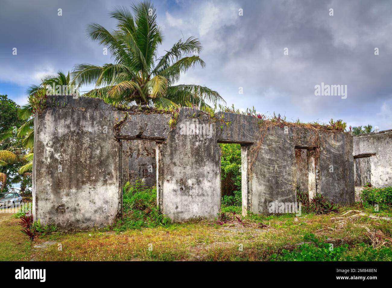 The shell of an unfinished, abandoned concrete building on the tropical ...