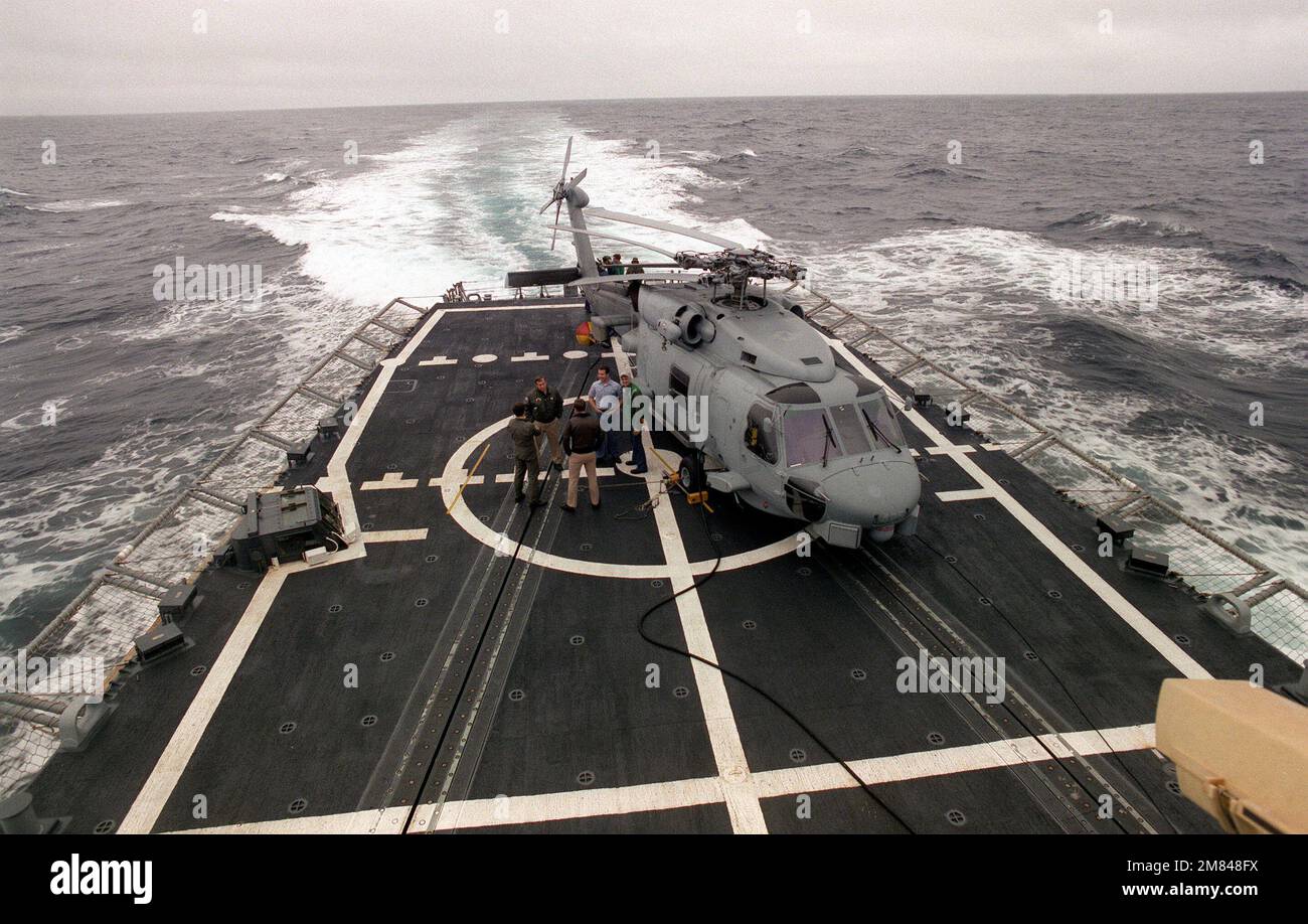 Crew members stand by to secure SH-60B Sea Hawk helicopter on the ...