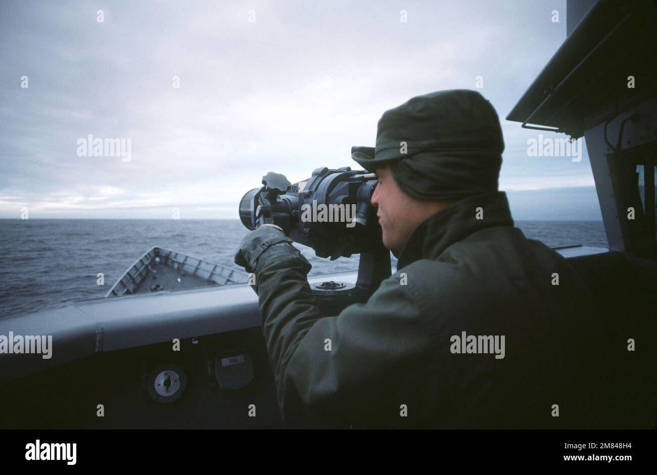 A lookout stands watch on the bridge of the guided missile frigate USS ...