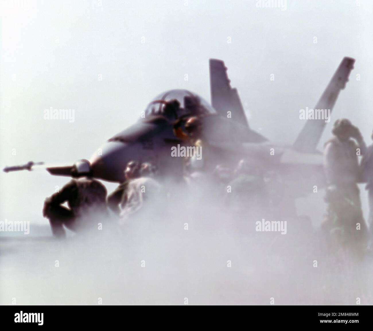 Flight deck crewmen prepare to launch an F/A-18 Hornet fighter aircraft ...