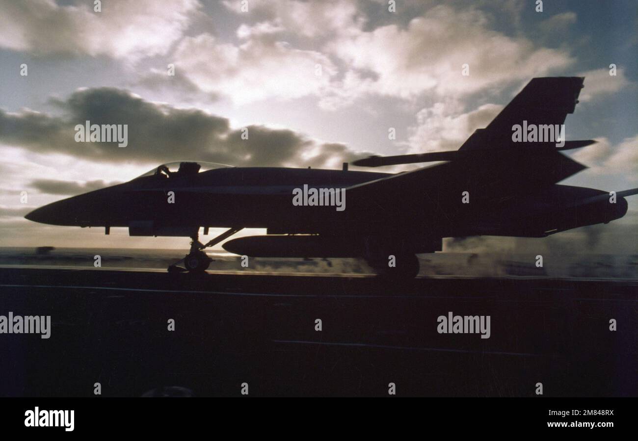 Silhouetted left side view of an F-14 Tomcat fighter aircraft preparing ...