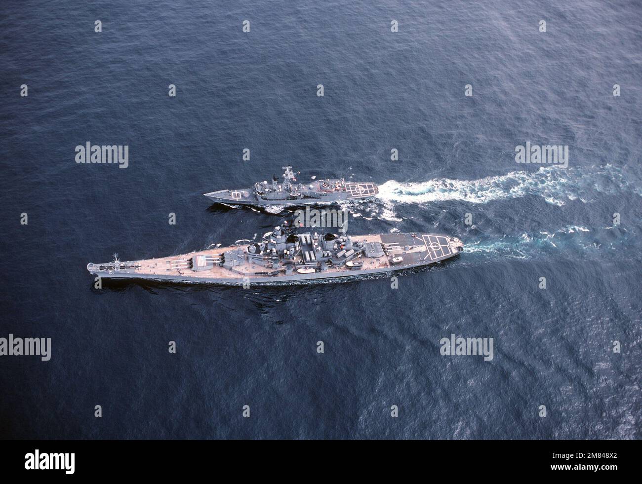 A high angle port view of the battleship USS IOWA (BB 61) refueling the guided missile destroyer ...