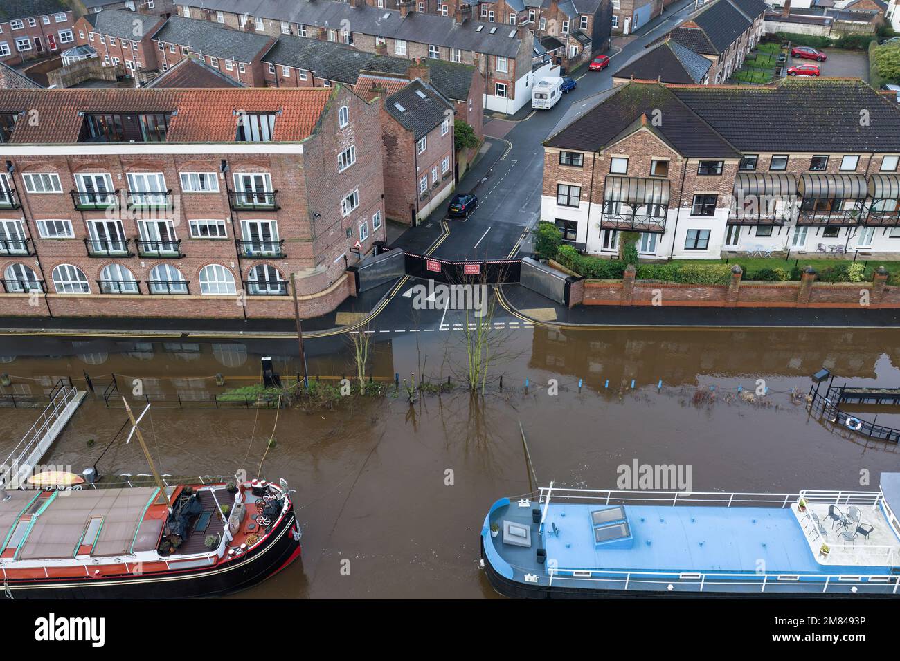 Road flood defences are put in place as heavy rain causes the River ...