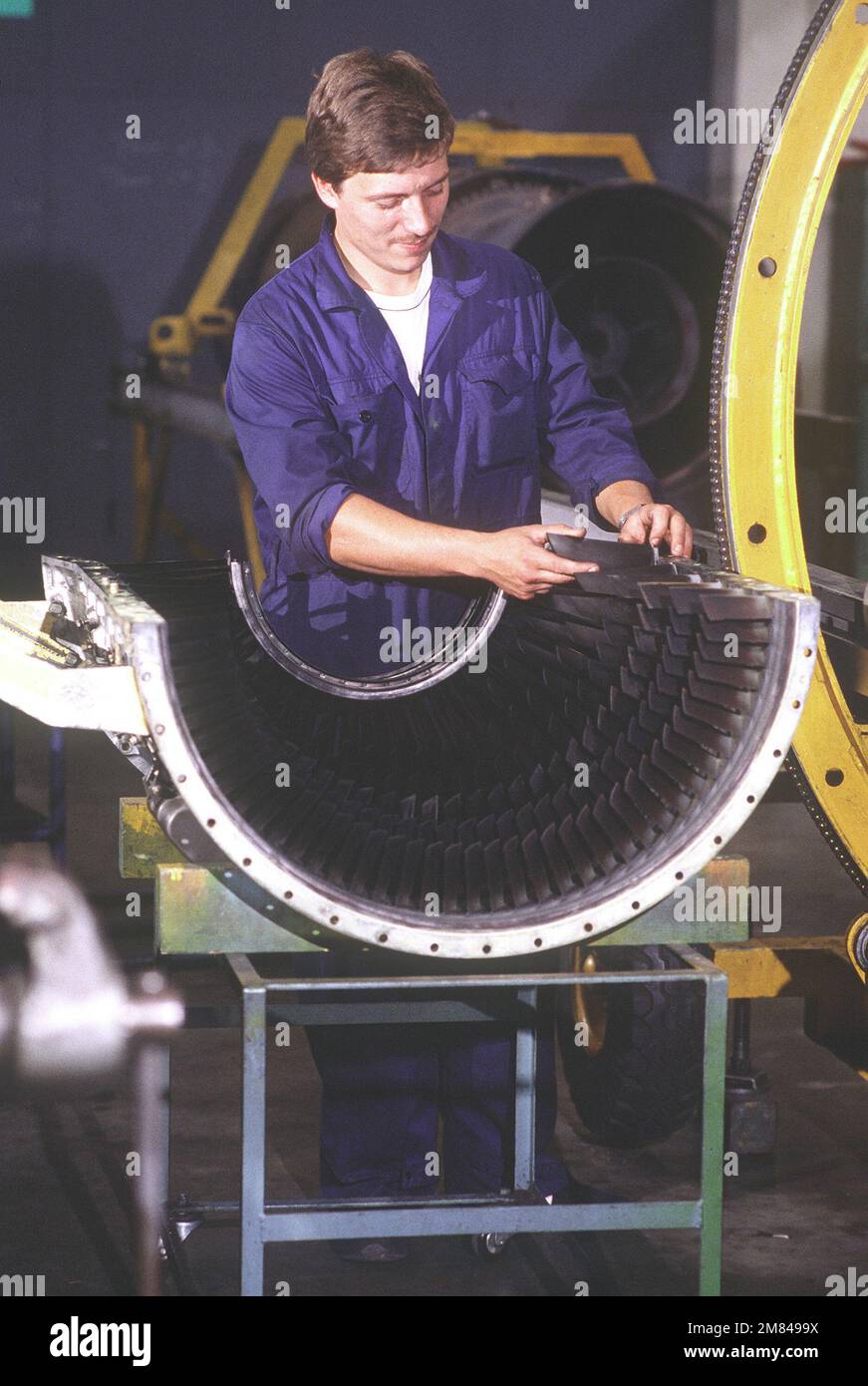 A Belgian aircraft engine mechanic polishes and installa a jet engine ...