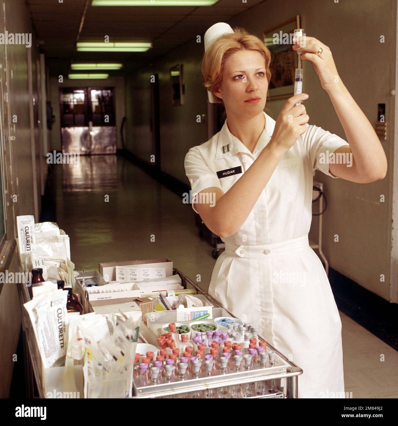 A U.S. Army nurse prepares a hypodermic syringe for an injection ...