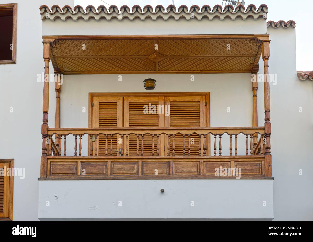 Closeup of balcony with wooden canopy, railing and horizontal sun blind ...