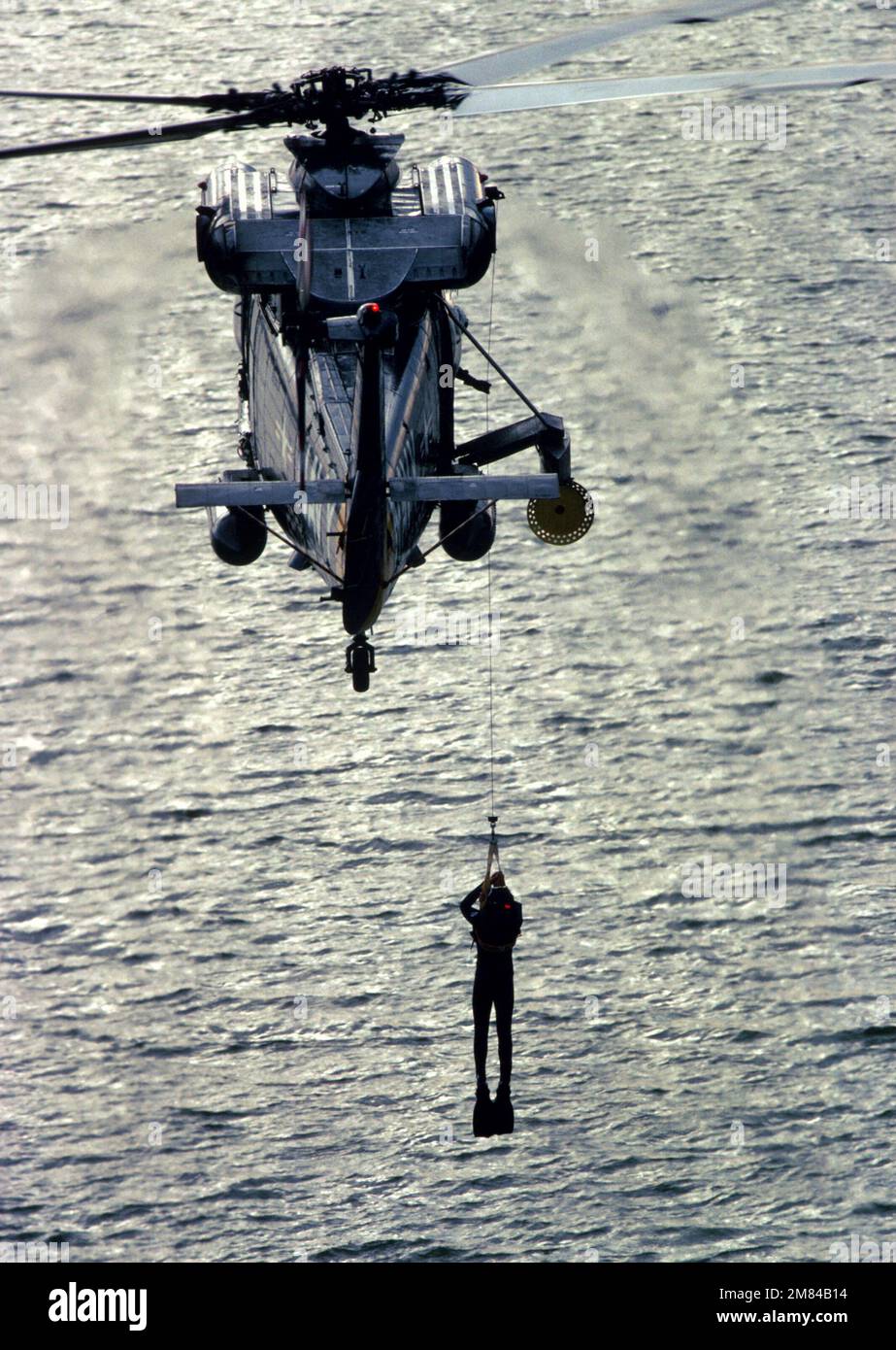 A search and rescue swimmer is hoisted aboard a Helicopter Light Anti ...
