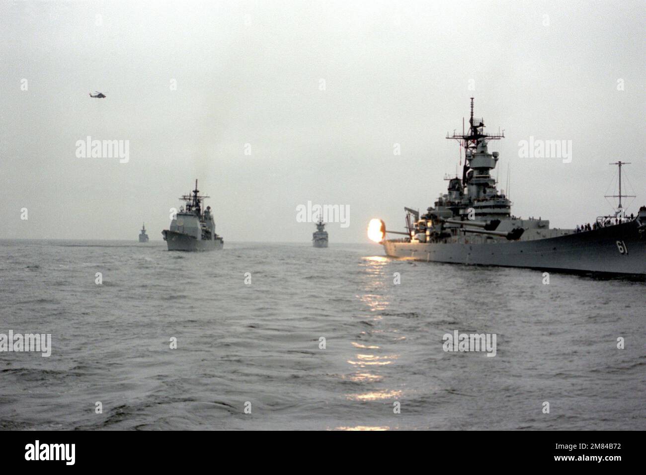 A starboard bow view of the battleship USS IOWA (BB-61) firing a ...