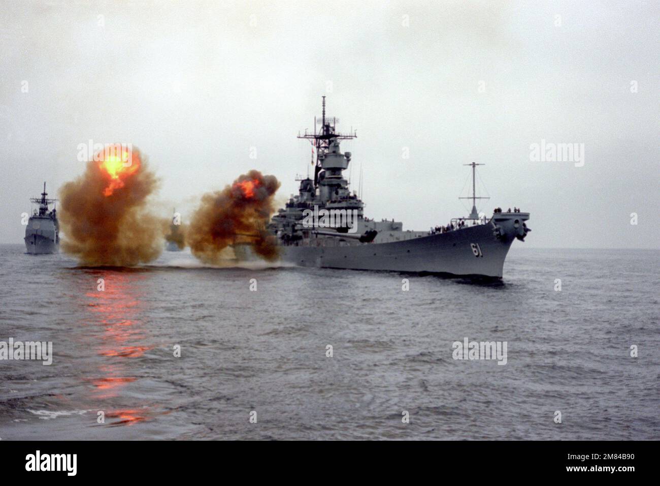 A starboard bow view of the battleship USS IOWA (BB-61) firing a ...