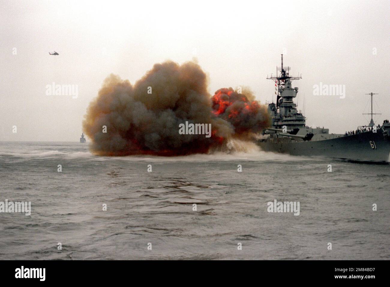 A starboard bow view of the battleship USS IOWA (BB-61) firing a ...