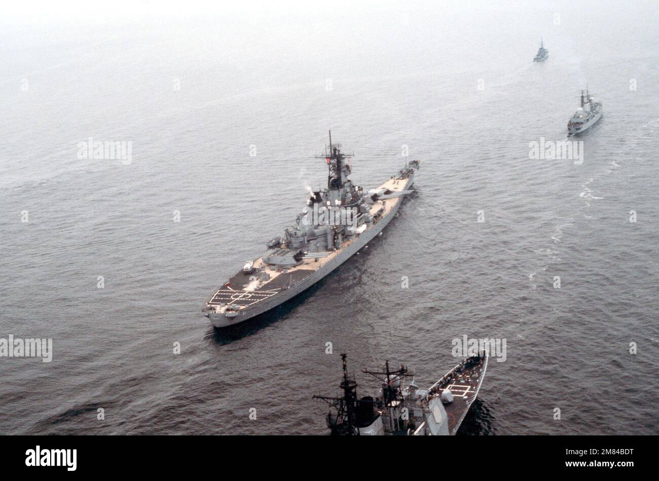 An aerial starboard quarter view of the battleship USS IOWA (BB 61) underway with task force ...