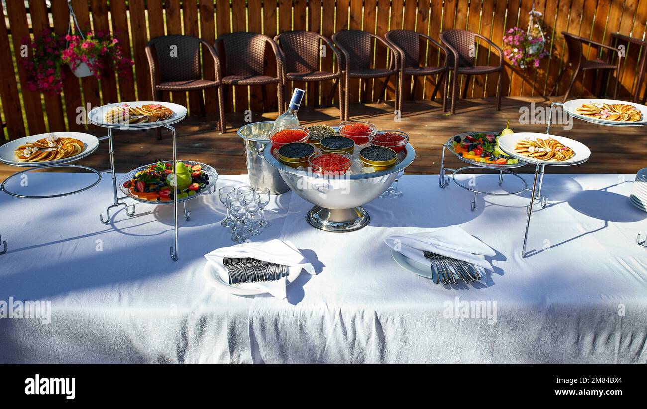 Covered and served furshet table, outdoor. Red and black caviar and ...