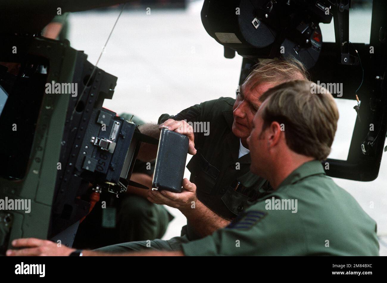 Two U.S. Air Force technicians adjust an aircraft camera during the ...