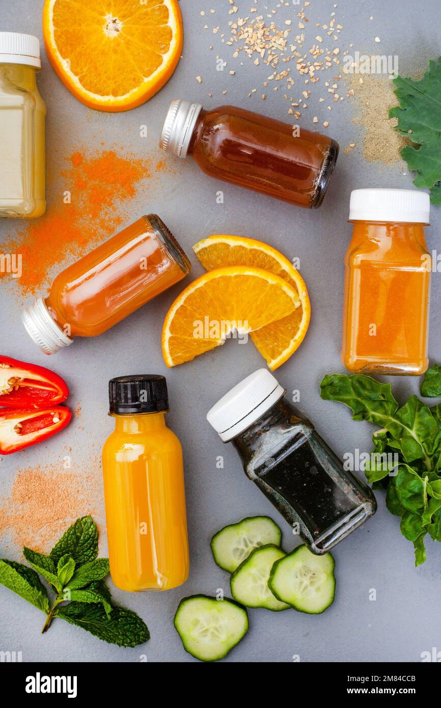 Juice shots for a healthy lifestyle, flat lay on dark grey with ...