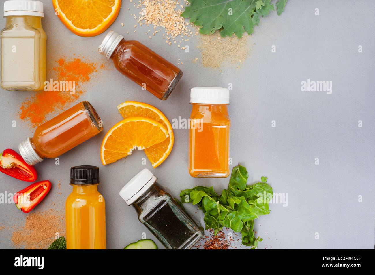 Juice shots for a healthy lifestyle, flat lay on dark grey with ...