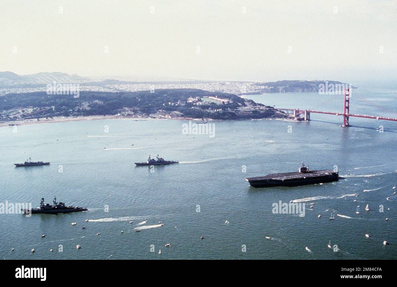 Aerial port view of the destroyer USS PAUL F. FOSTER (DD 964) followed ...