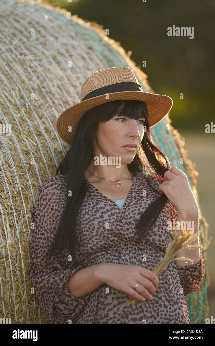 A beautiful rural girl thoughtfully sorts through her long black hair ...