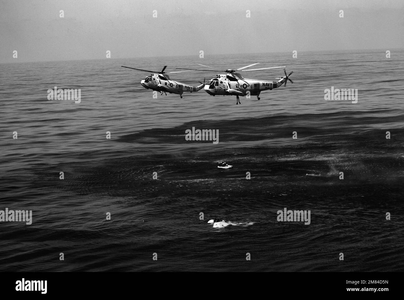 U.S. Navy divers wait to be lowered from two Helicopter Anti-submarine ...