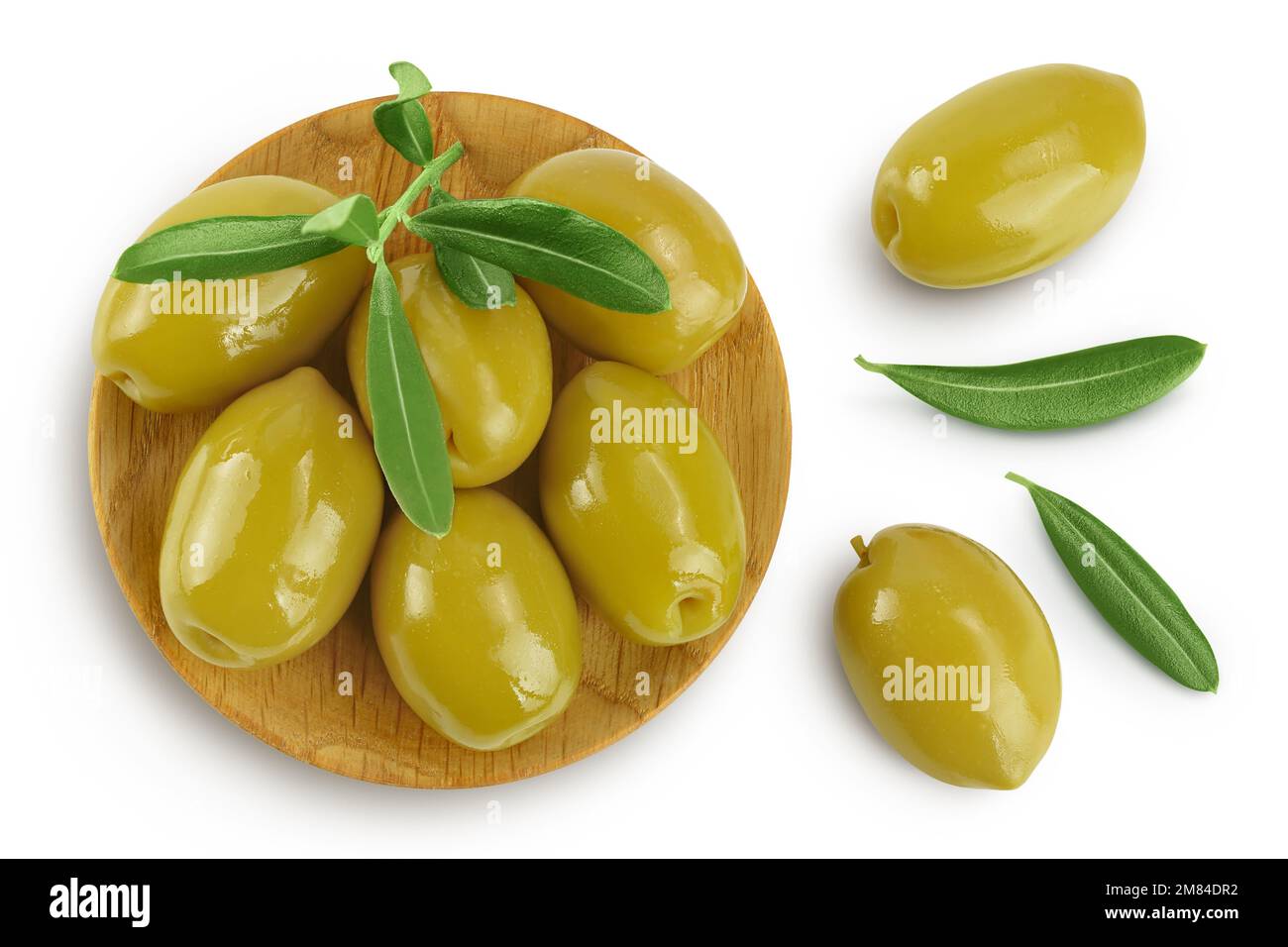 Green olives with leaves in wooden bowl isolated on a white background ...