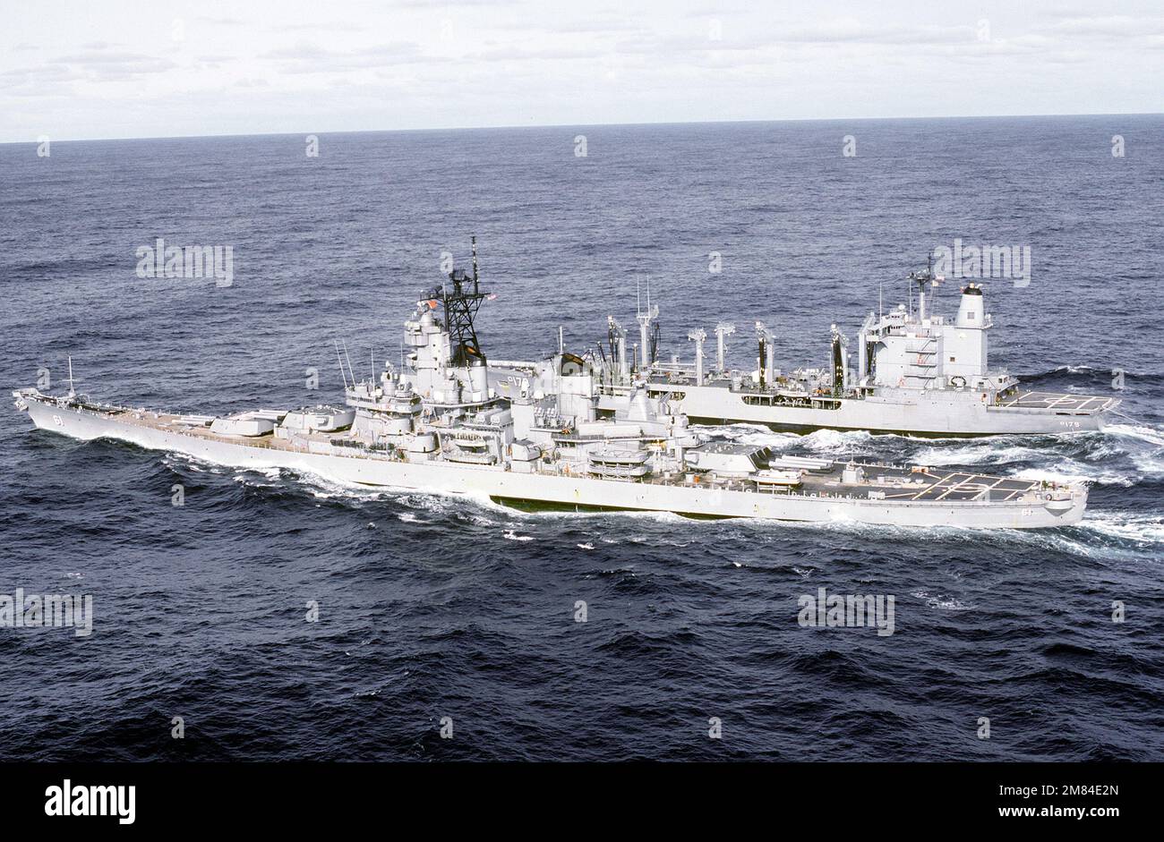 An elevated port side view of the battleship USS IOWA (BB-61) being refueled by the fleet oiler ...