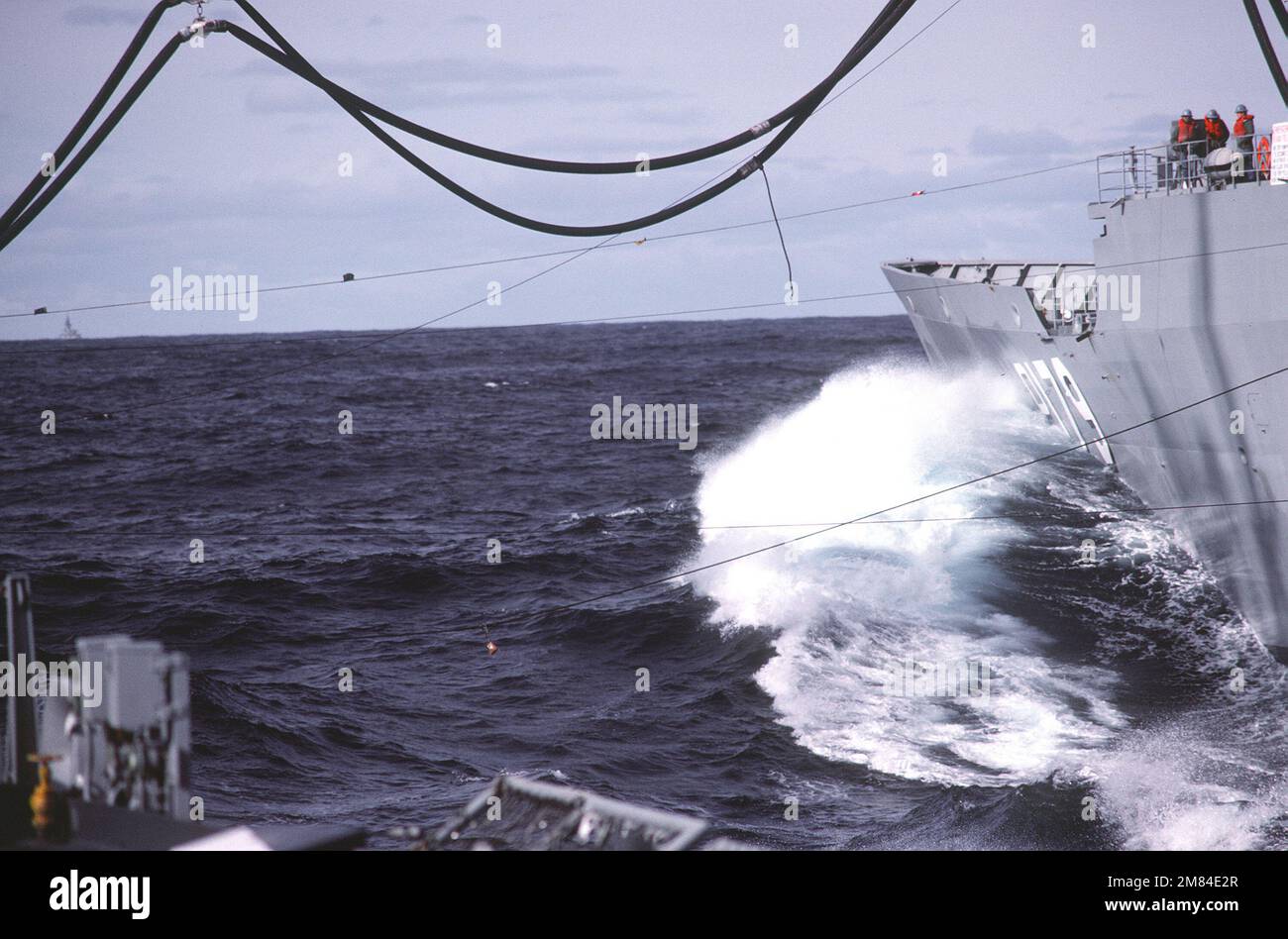 The fleet oiler USS MERRIMACK (A0-179) refuels a ship during an ...