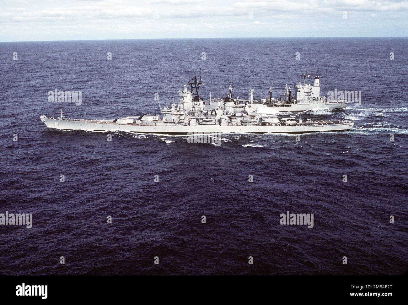 An elevated port side view of the battleship USS IOWA (BB-61) being refueled by the fleet oiler ...
