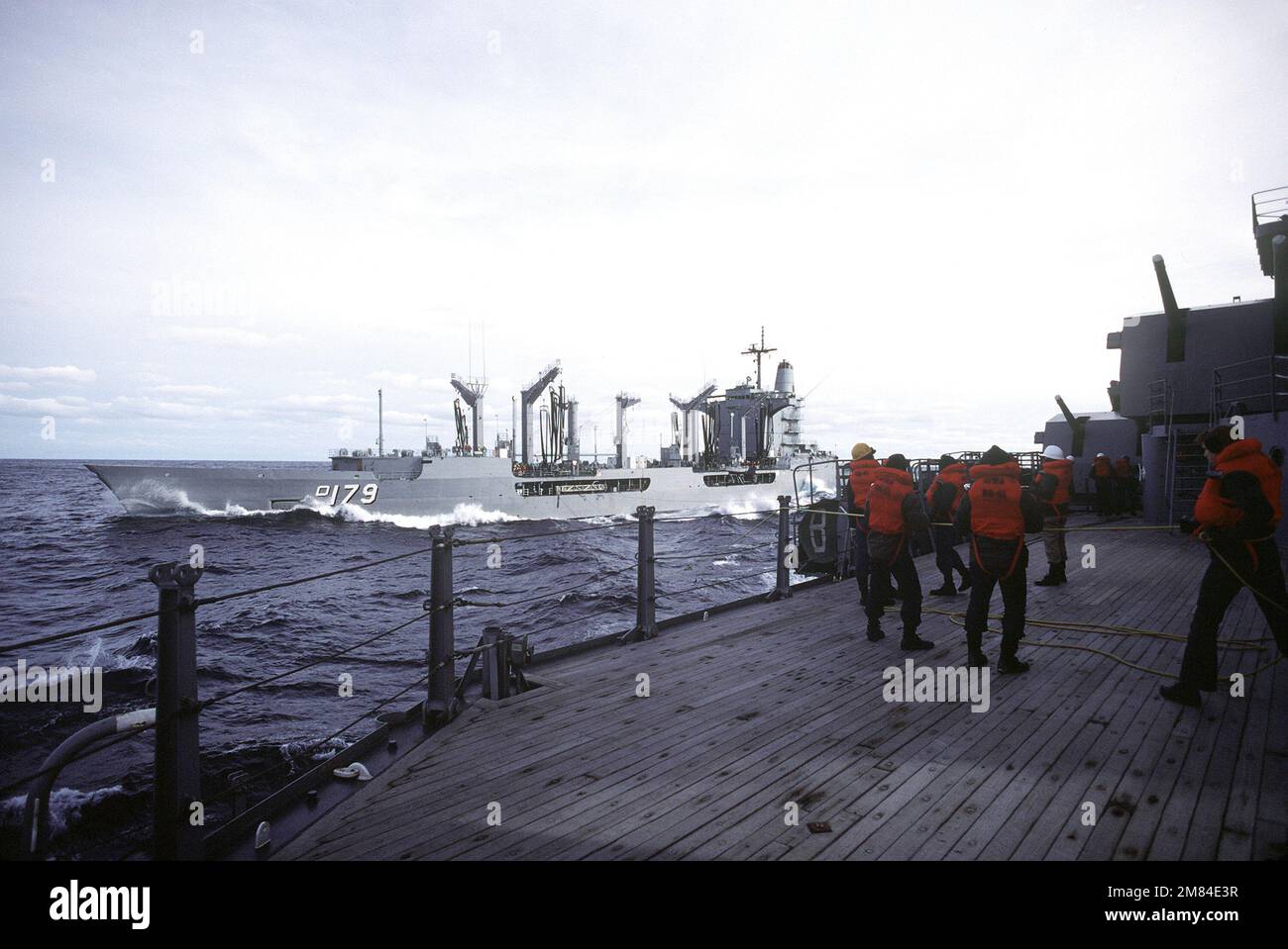 Crewman aboard the battleship USS IOWA (BB-61) rig refueling lines ...