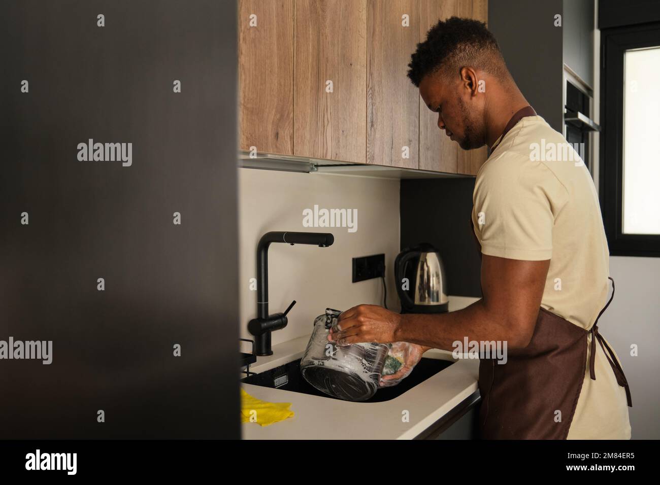 Young black man hand washing stainless steel pot with soap Stock Photo ...