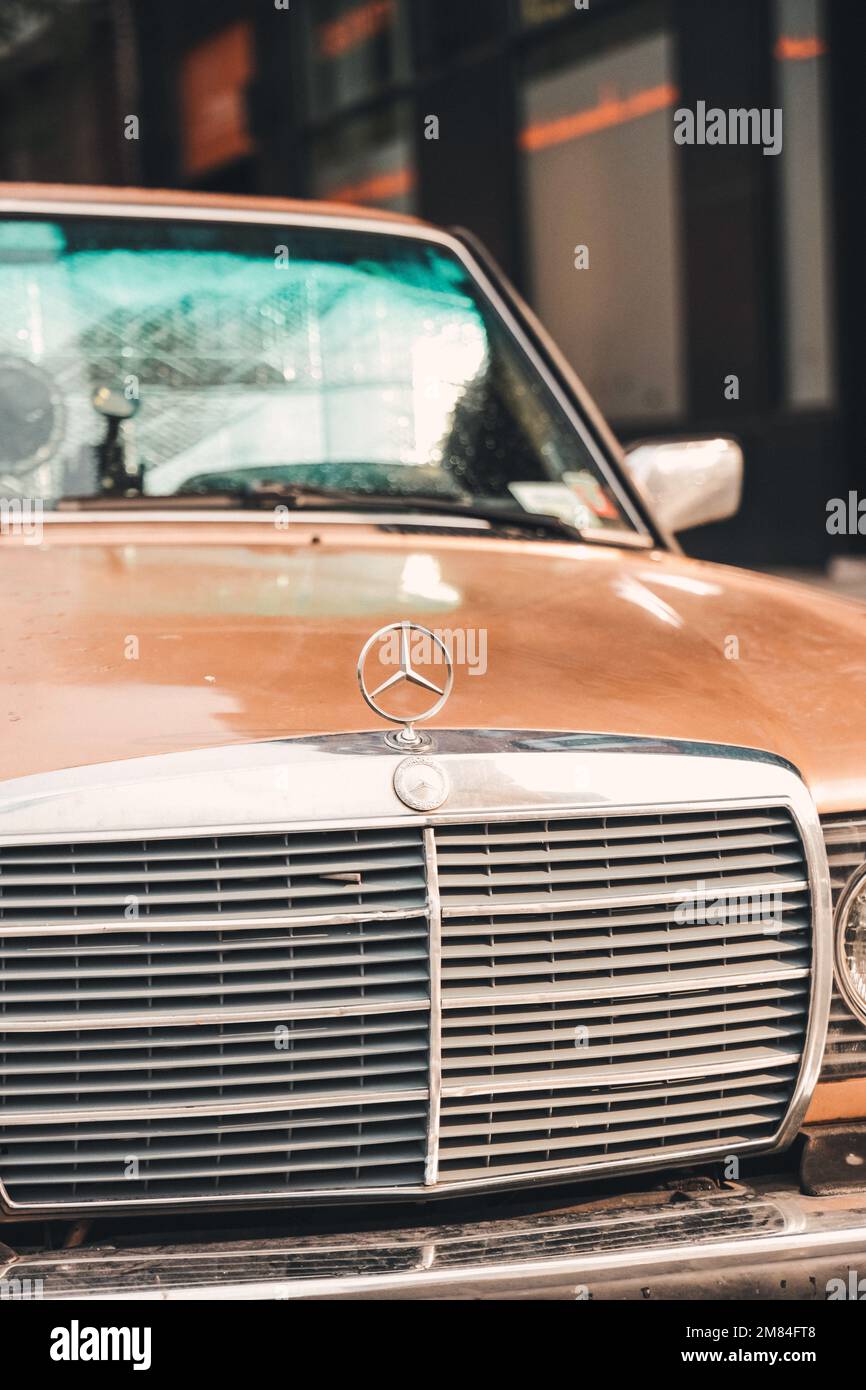 A vertical closeup shot of a front part of an old Mercedes Benz on the ...