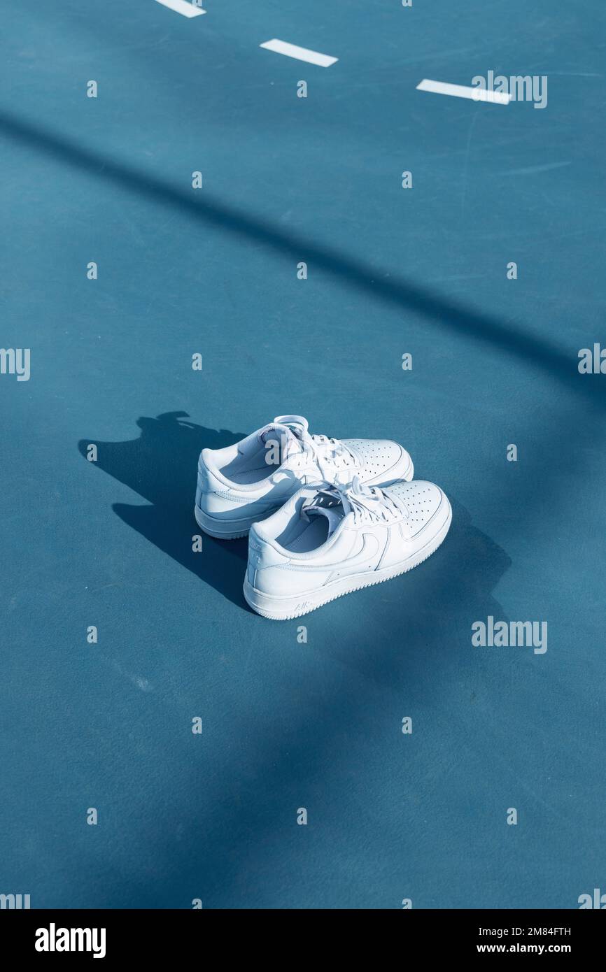 A vertical shot of white Nike sneakers on a basketball court Stock ...