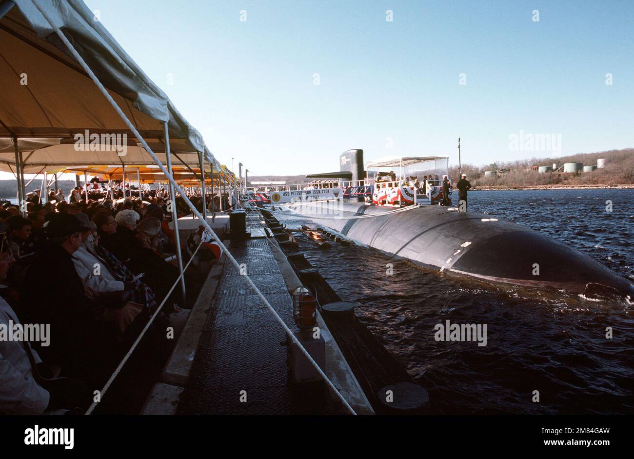 A Navy officer addresses guests from the speakers platform aboard the ...