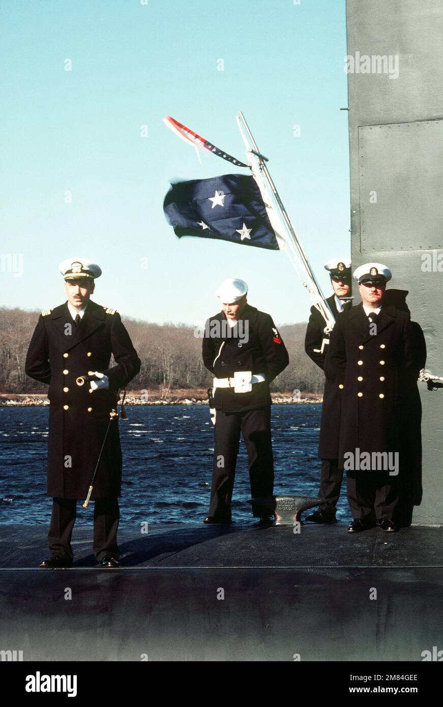 Standing at parade rest below a vice admiral's flag and the ...