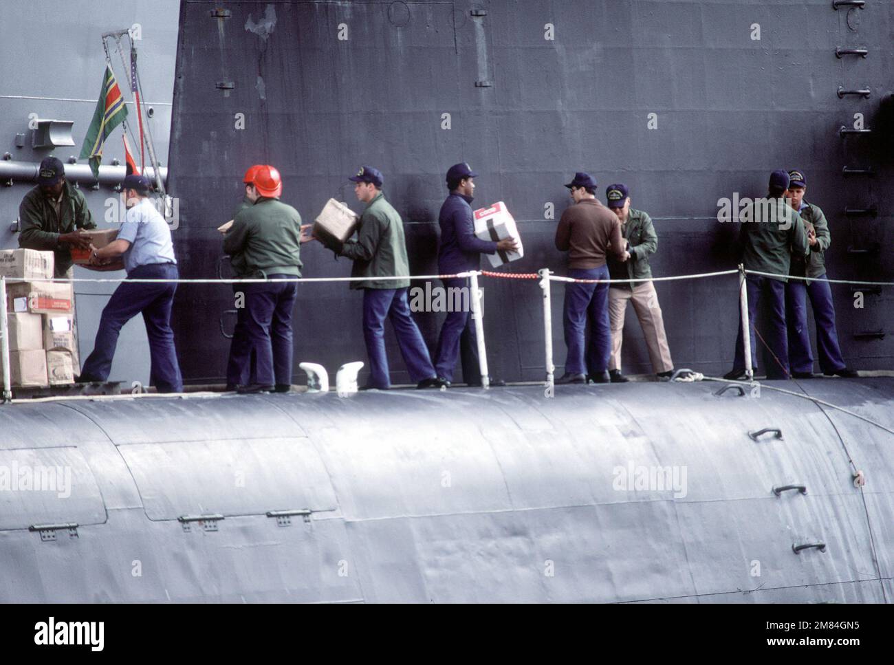 Crewman load supplies aboard a submarine at Navy Fleet Ballistic ...