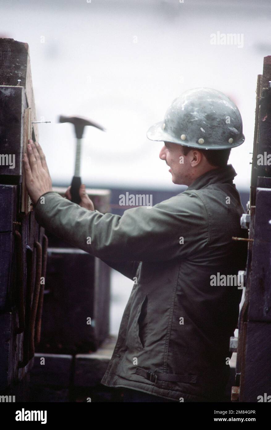 A hull technician works on the wooden ship supports aboard the large ...