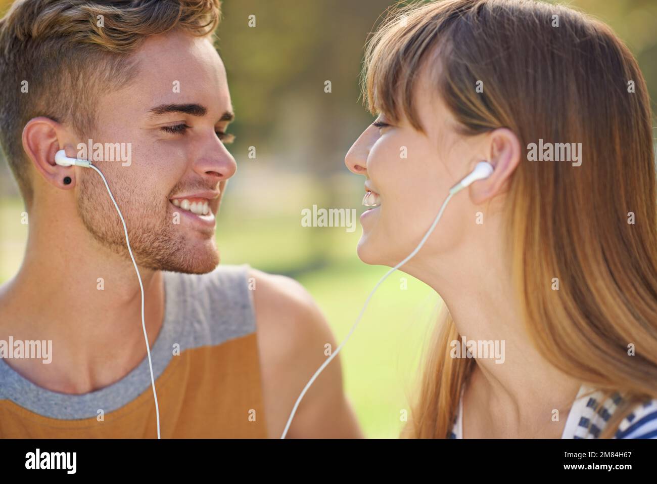 This is our song...A loving young couple sharing a pair of earphones ...
