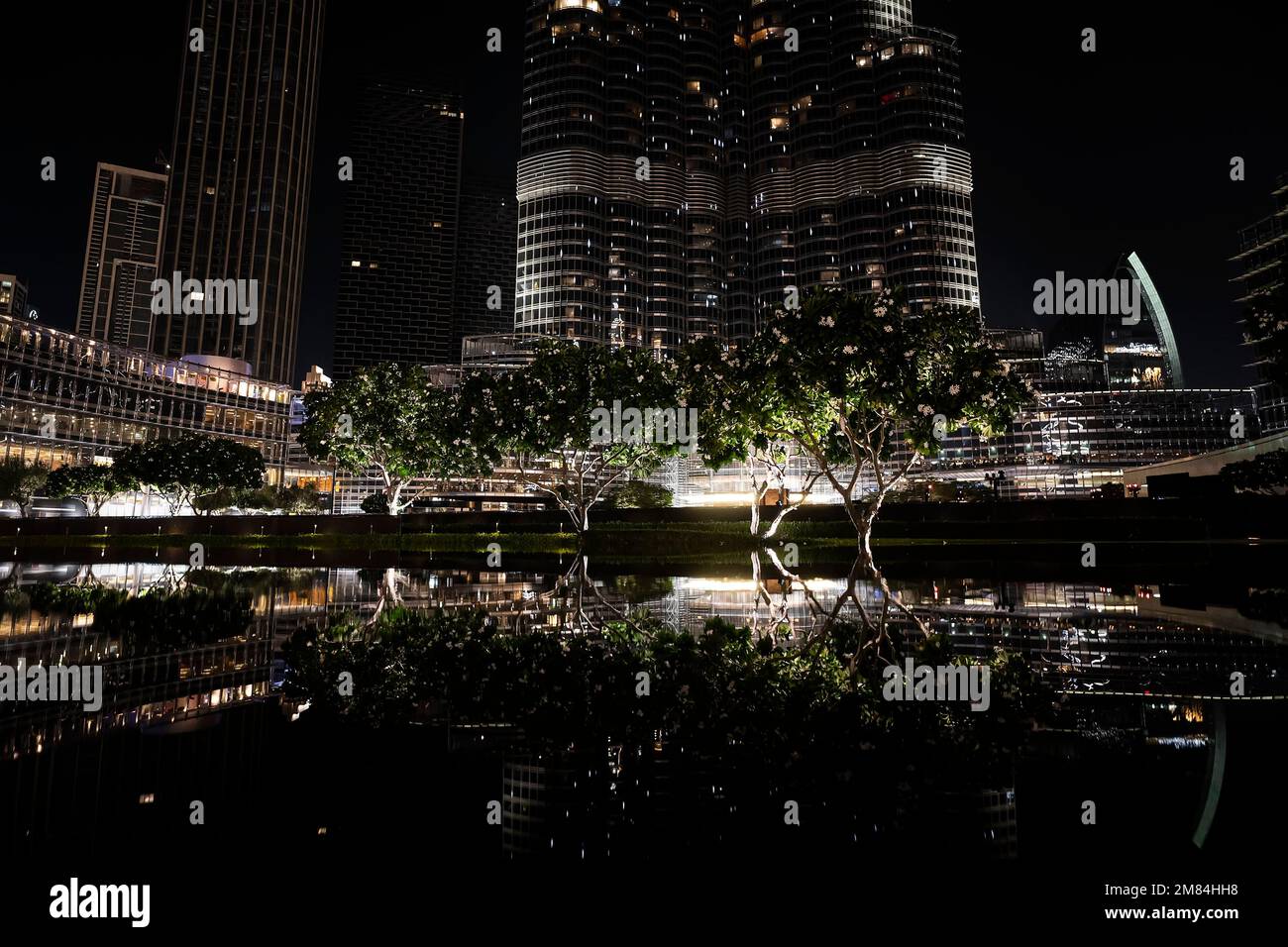 beautiful reflection of skyscraper houses in calm water at night in ...