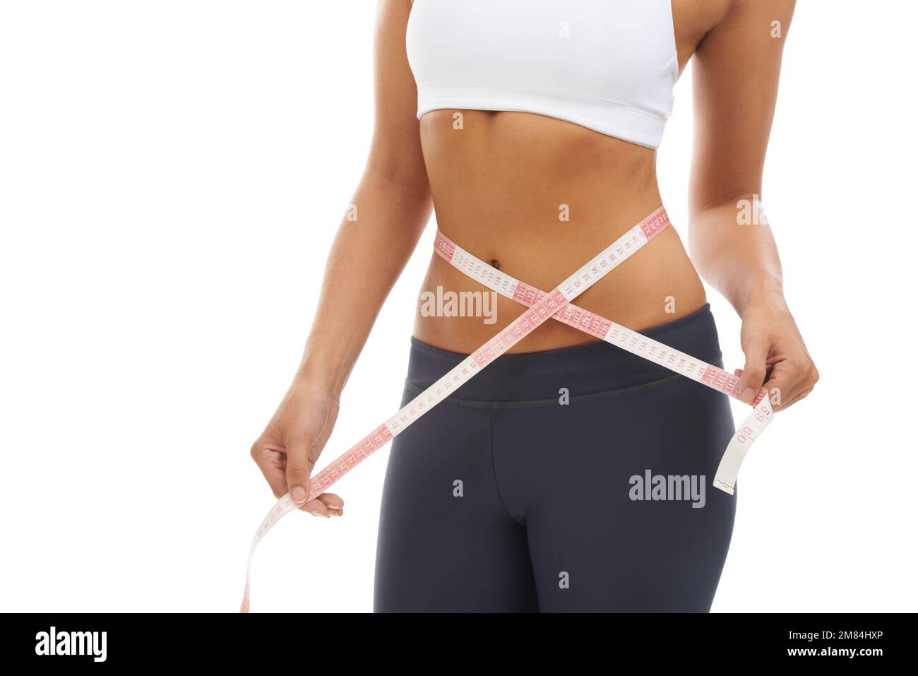 Perfect the way she is. A young woman measuring her slim waist and charting her weight loss ...