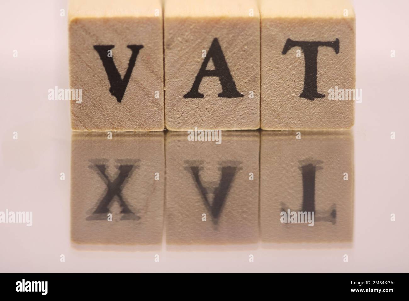 wooden cube block with VAT text with mirror reflection of TAX ...