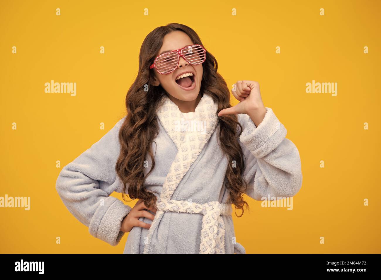 Teen girl in funny glasses and pajama or home bathrobe feeling fun ...