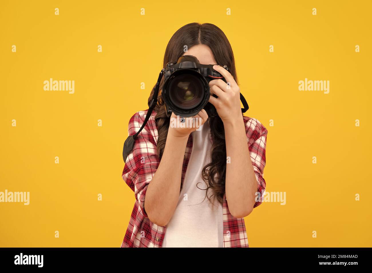 Teenager girl photographer with a dslr camera. Kid use digital camera ...