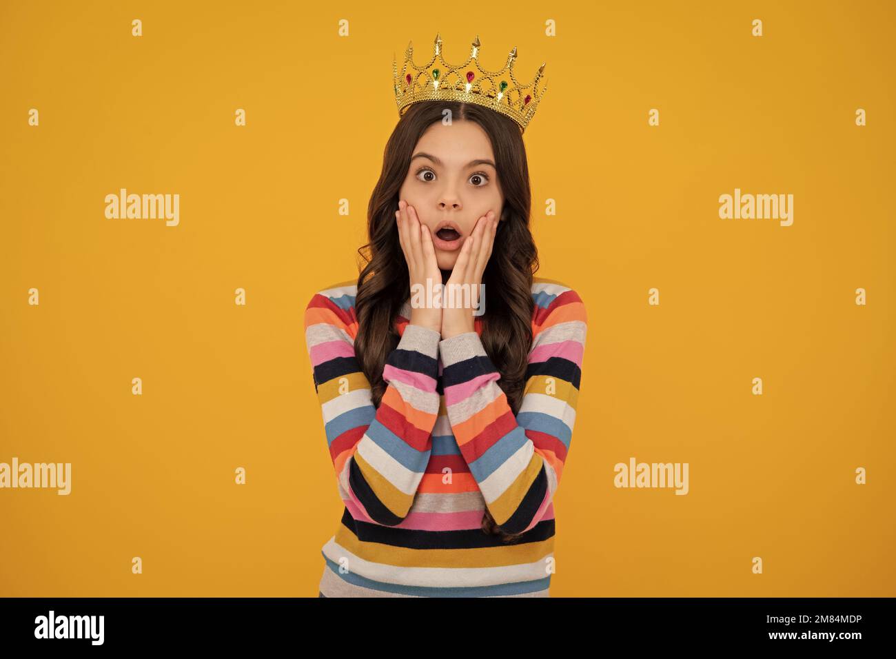 Teen child in queen crown isolated on yellow background. Princess girl ...