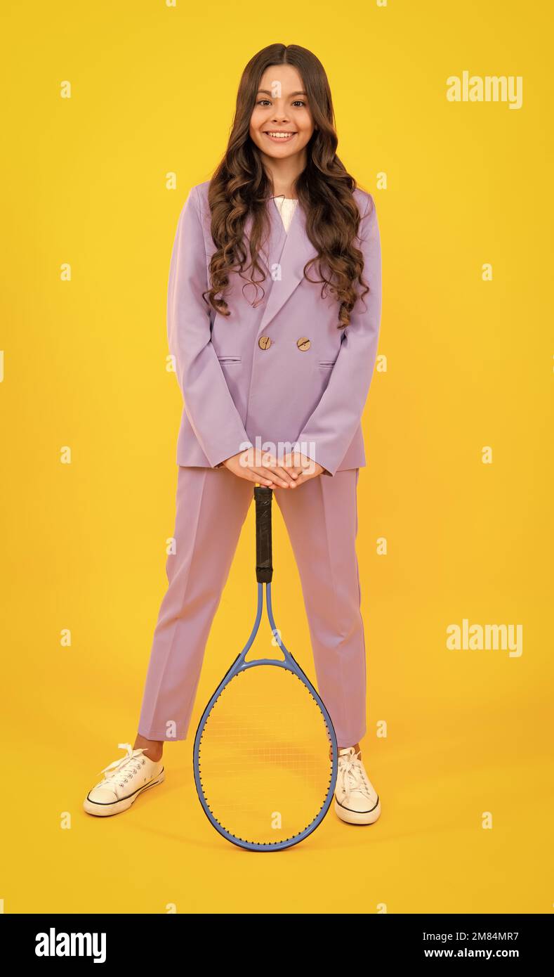 Child tennis player hold tennis racket over isolated yellow background ...
