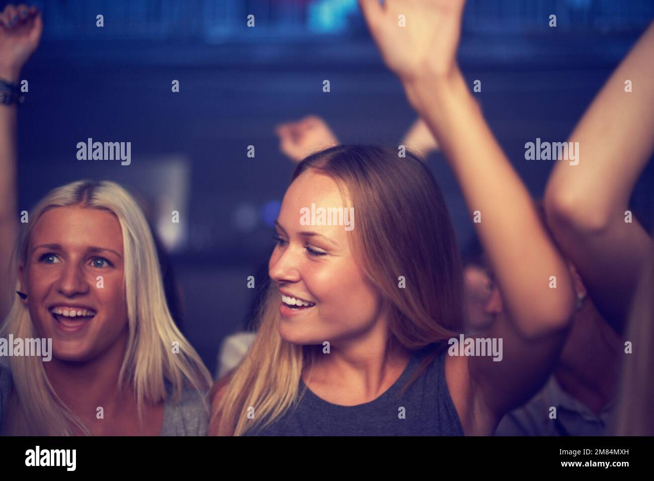 Enjoying the music. A group of people standing with their arms raised ...
