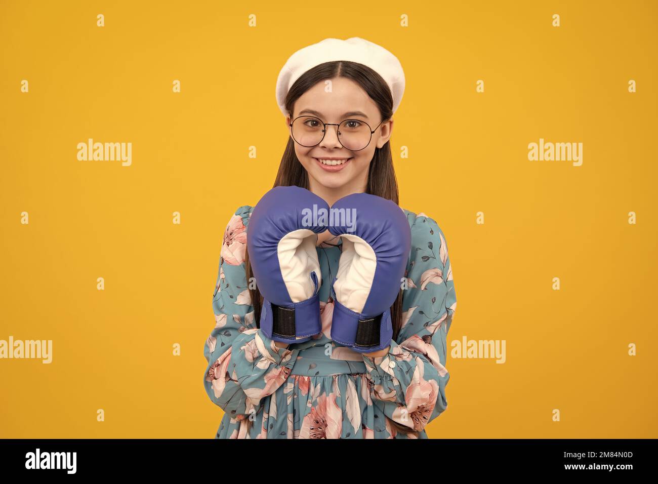 Portrait of funny surprised winner teenage girl in boxing gloves ...